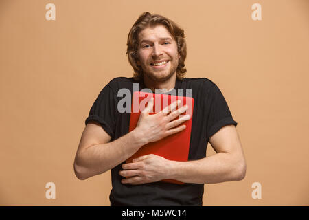 Businessman hugging laptop at studio Stock Photo - Alamy