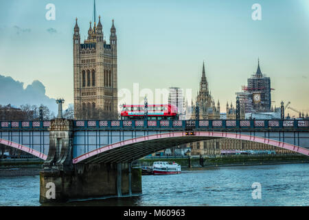 A red bus crossing the Lambeth bridge in London during a stormy day ...