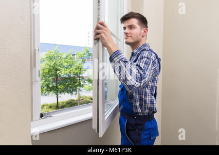 Male worker installing window in flat Stock Photo - Alamy