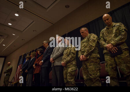 Distinguished guests bow for a prayer during a combined ceremony for ...