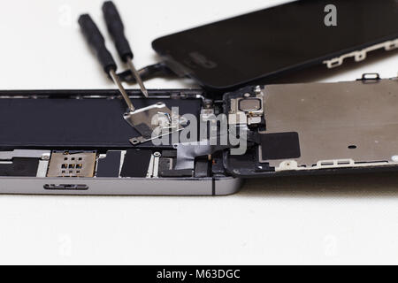 Old broken smartphone and repair tool. The concept of computer ...