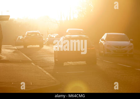 cars being blinded by low winter sun driving along road in the uk Stock ...
