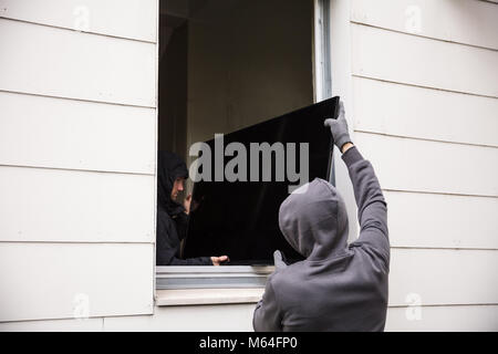 Robbers Stealing Television Through House Window Stock Photo - Alamy