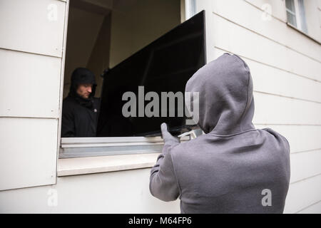 Robbers Stealing Television Through House Window Stock Photo - Alamy
