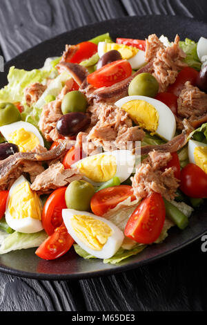 Colorful tuna salad with fresh vegetables in a gray bowl on a rustic ...