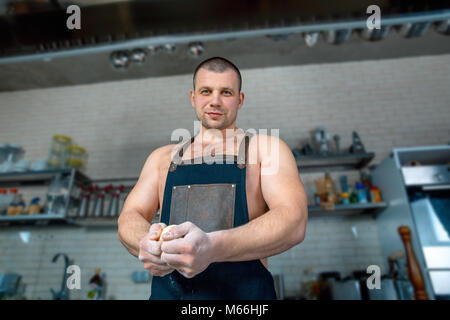 bodybuilder chef in hotel or restaurant kitchen interior knead the ...