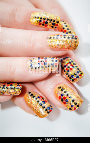 Female hand with long nails and purple plum manicure holds a bottle of ...