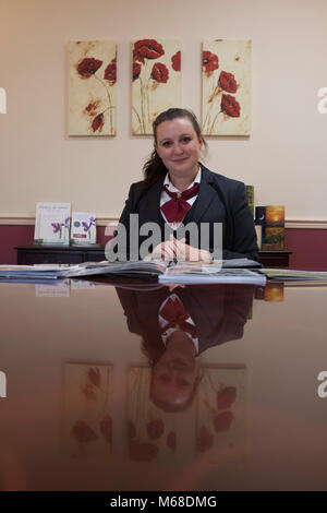 a female member of staff at an undertakers helps to plan a funeral with ...