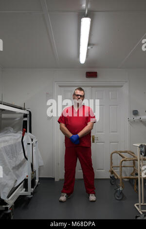 a male embalmer poses for a portrait behind the scenes in an ...