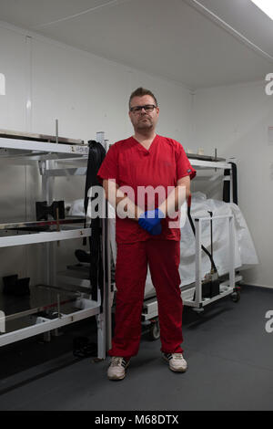 a male embalmer poses for a portrait behind the scenes in an ...