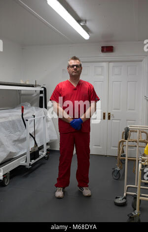 a male embalmer poses for a portrait behind the scenes in an ...