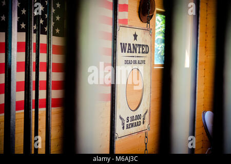 Wild West jail and wanted sign with american flag in the background ...
