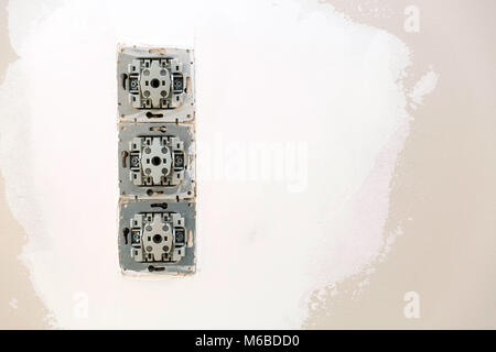 Repairing damaged light switches, installing new Stock Photo - Alamy