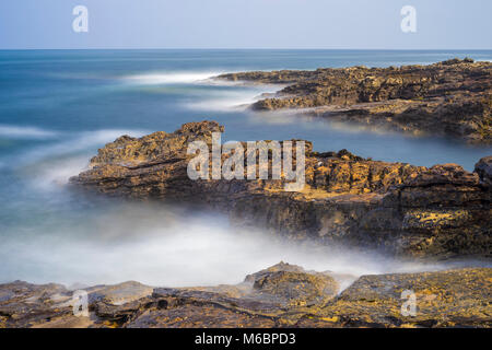 A long exposure image of the sea washing in around rocks at Porth Nobla ...