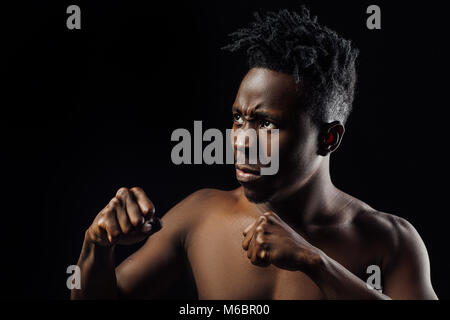 Strong body of African male boxer against black background with copy ...