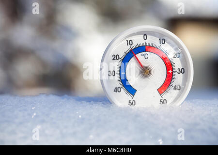 Thermometer with celsius scale placed in a fresh snow showing sub-zero ...