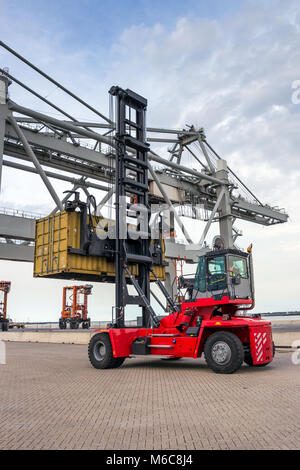 Mobile cargo container handler in action at a shipping container ...