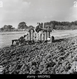 1950s, agriculture, a farmer on a tractor carefully ploughing a field ...