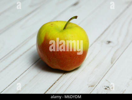 one yellow apple lies on a black old wooden table, apple on a board ...