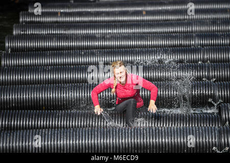 Participant crossing a water obstacle during Action run 2017 obstacle ...
