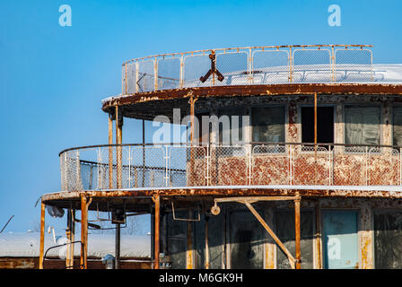 Old rusty ferries located near snowy shore of harbor against cloudless ...