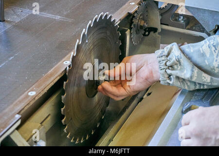 Unrecognizable carpenter sets table saw blade for wood while working in ...