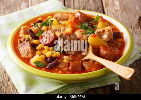 Cape Verde food cachupa with meat, sausages and vegetables close-up in ...