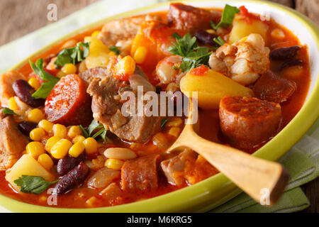 Cape Verde food cachupa with meat, sausages and vegetables close-up in ...