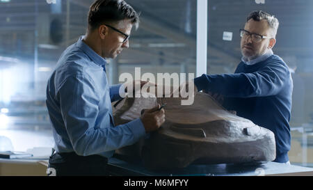 Two male automotive designers sculpting futuristic plasticine clay ...
