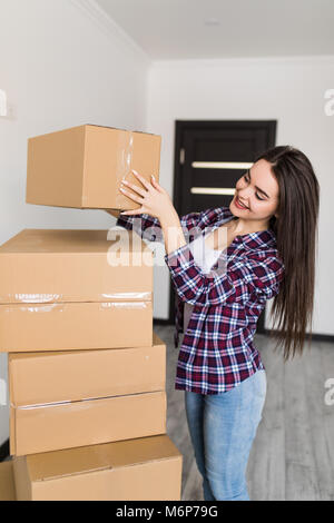 Young beautiful hispanic woman unpacking gift sitting by christmas tree ...
