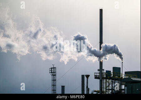 Industrial smoke stacks against ominous skies Stock Photo - Alamy
