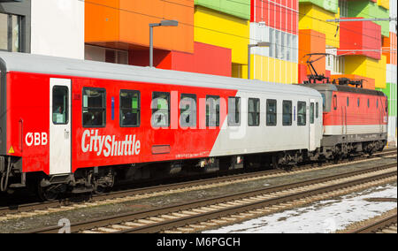 Red electric locomotive in OBB livery, with passenger train at a ...