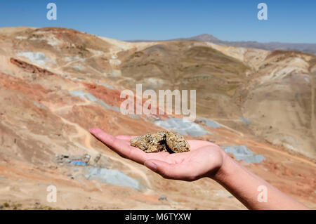 The Cerro Rico hillside and ore silver on the hand in the background of ...