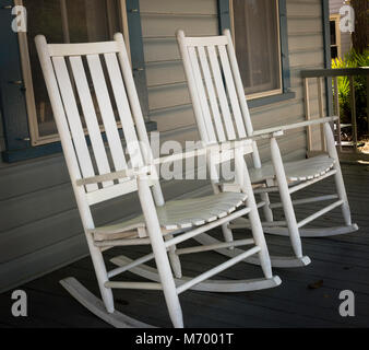 Old fashioned white rocking chairs on the front porch of an old cabin ...