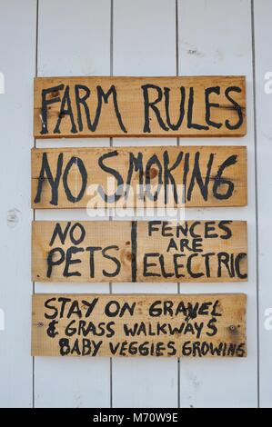 "Farm Rules" hand-lettered wooden sign hanging on side of outbuilding ...