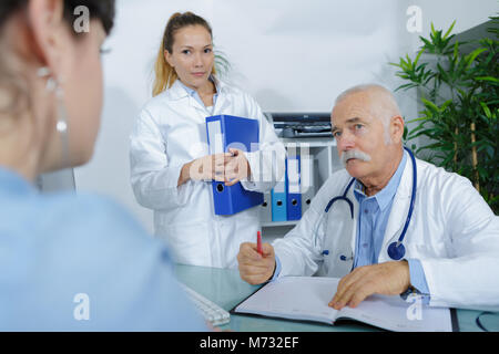 Doctor and patient are discussing something, just hands at the table ...