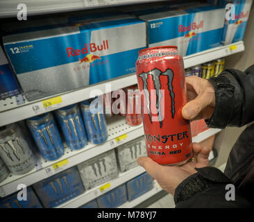 A display of Monster energy drinks cans on the shelves of a grocery ...