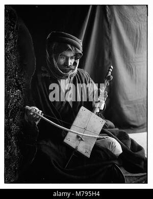 Bedouin man playing the rababeh (a single string instrument) with a bow ...