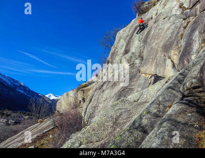 Male rock climber in red on cliff above Ax Les Thermes, Ariege, French ...