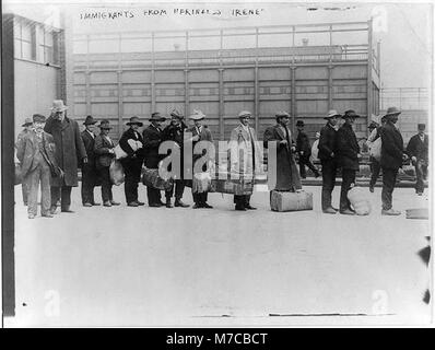 A historic photograph of immigrants arriving at Ellis Island, captured ...