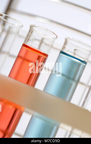 Three glass test tubes in stand, two containing oil and water, and one ...