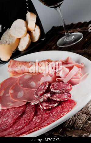 Wineglass with red wine and meat cuts board Stock Photo - Alamy