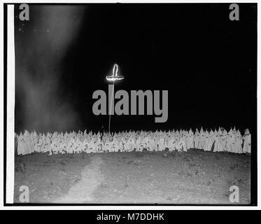 This photograph depicts members of the Ku Klux Klan at the U.S. Capitol in 1925. It reflects a ...