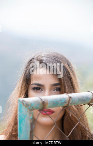 Young woman standing behind restriction tapes with eyes covered in ...