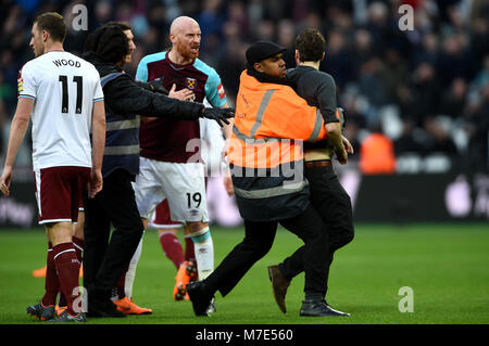 A Pitch invader is confronted by security during the Premier League ...