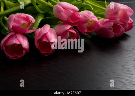 Border from bright pink tulips flowers on black wooden background Stock ...