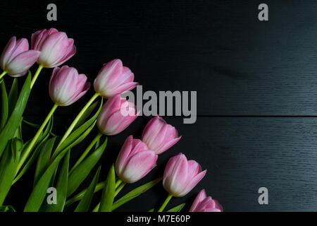 Border from bright pink tulips flowers on black wooden background Stock ...
