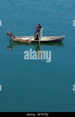 Fisherman pulling fish from river Stock Photo - Alamy