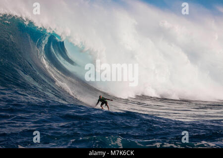 A tow-in surfer drops down the face of Hawaii's big surf at Peahi (Jaws ...