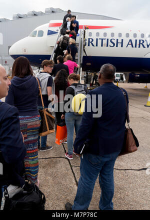 Passengers queue for their plane at Heathrow Airport Terminal 4 London ...